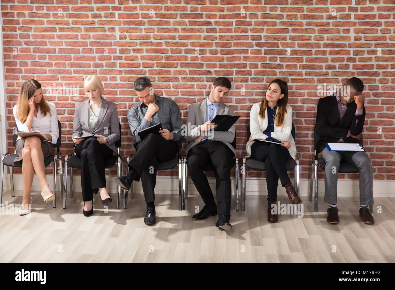 Row Of Diverse Professional Applicants Waiting To Be Called For An ...