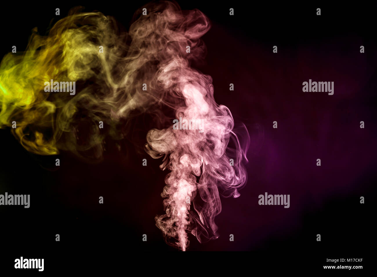 Dense multicolored smoke of yellow and pink colors on a black isolated ...