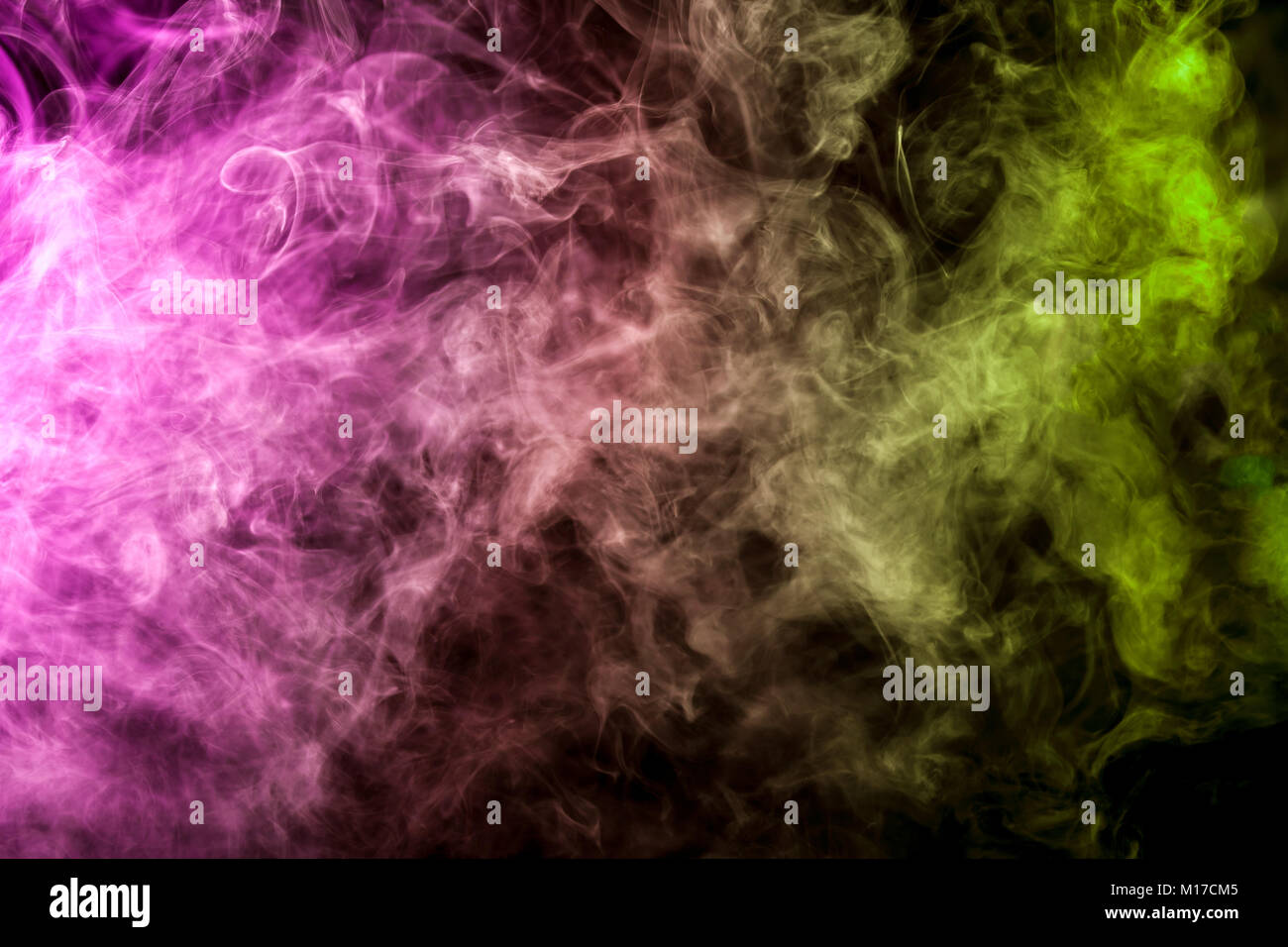 Colorful pink and yellow smoke clouds on dark background.Background of ...