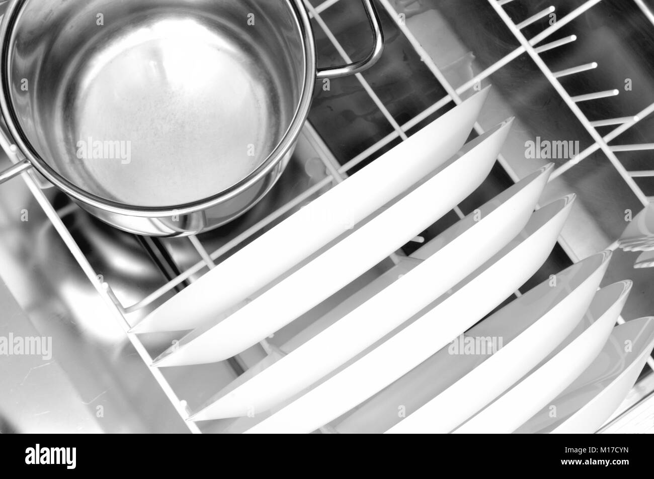 clean dishes and a steel pot in the dishwasher basket, from above ...
