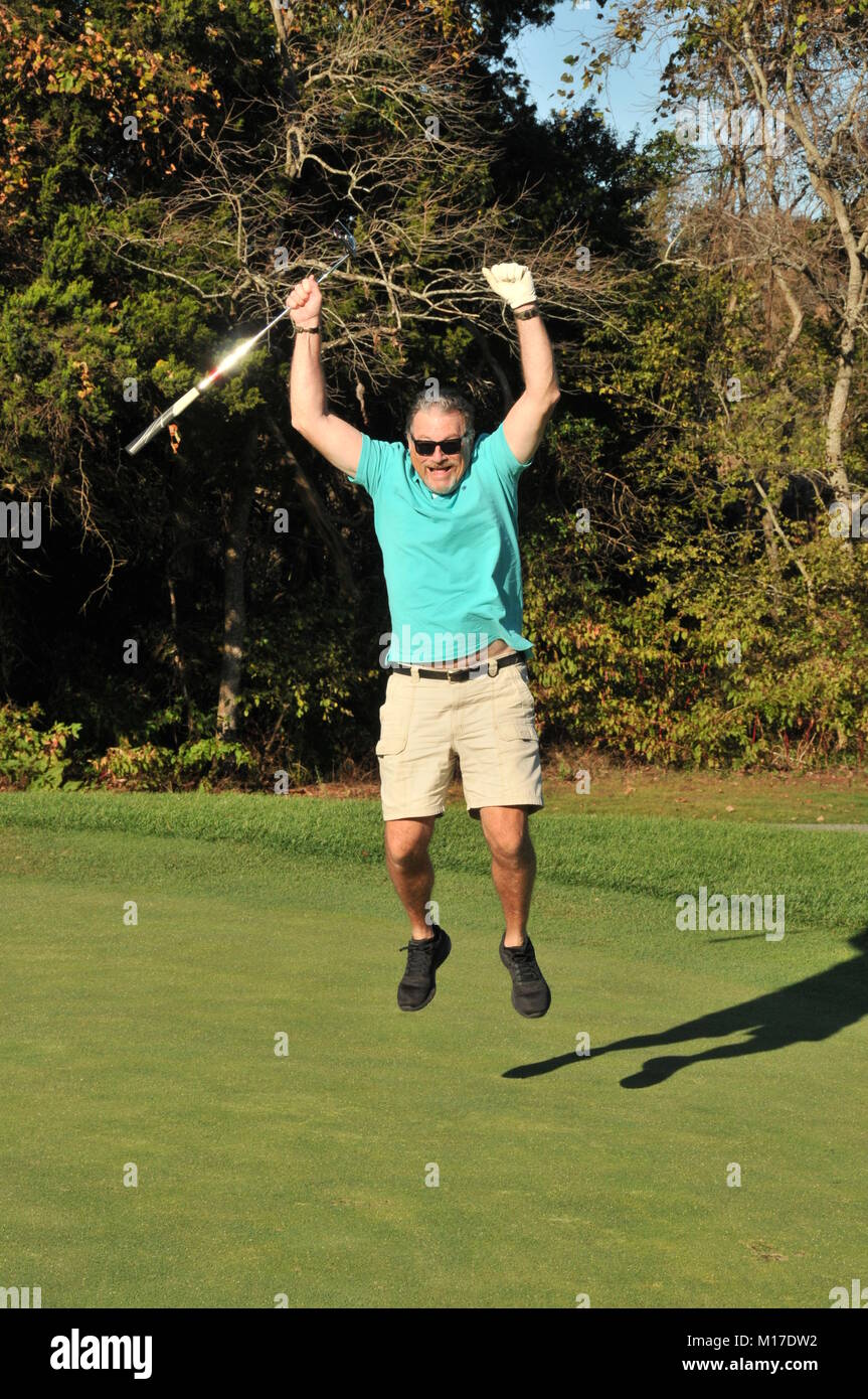 Golfer jumping in the air after sinking a long putt Stock Photo - Alamy