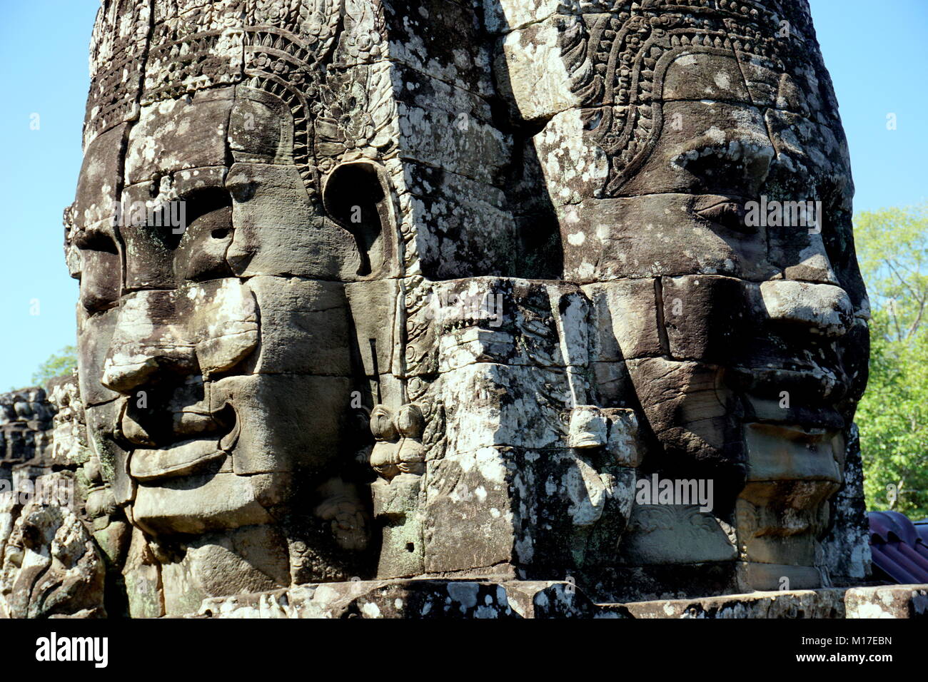 Close up of two faces engraved in the temples stone at Bayon Temple in ...