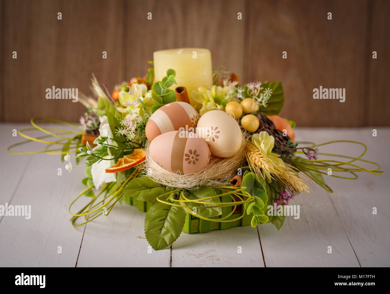Decorated Easter candlestick with painted eggs with flowers on wooden ...