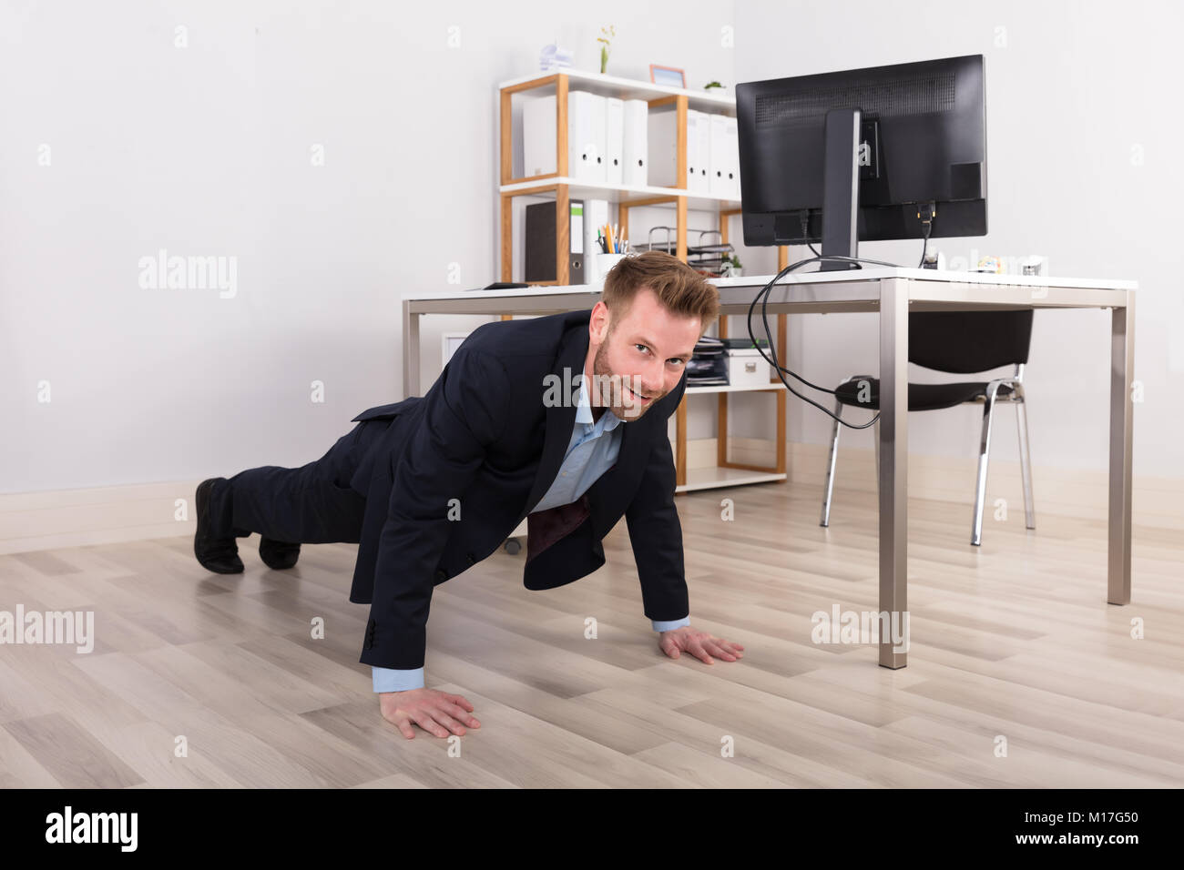 Young Businessman Doing Pushups On Hardwood Floor Stock Photo - Alamy