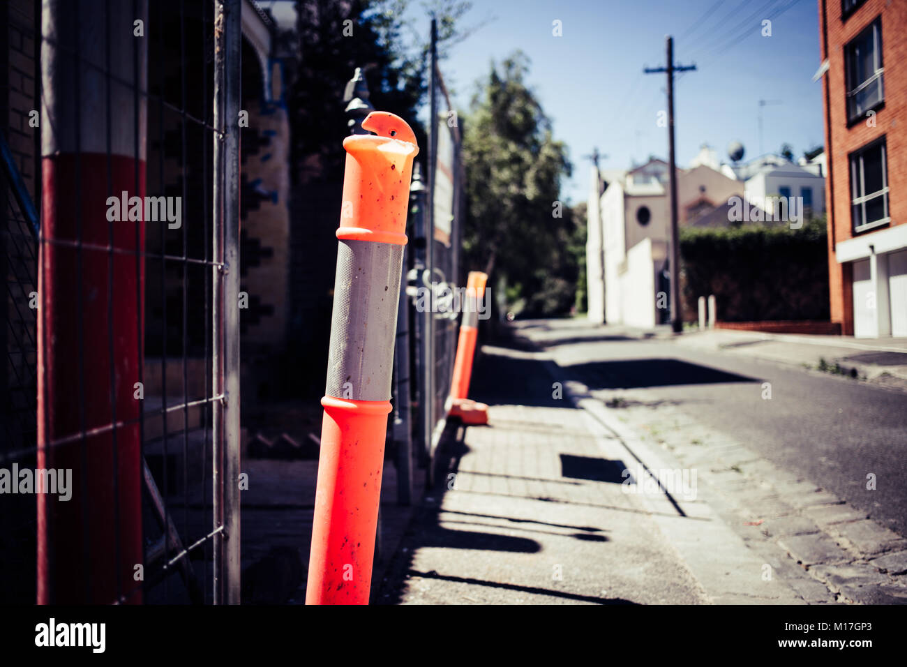 Orange safety pole on the sidewalk Stock Photo - Alamy