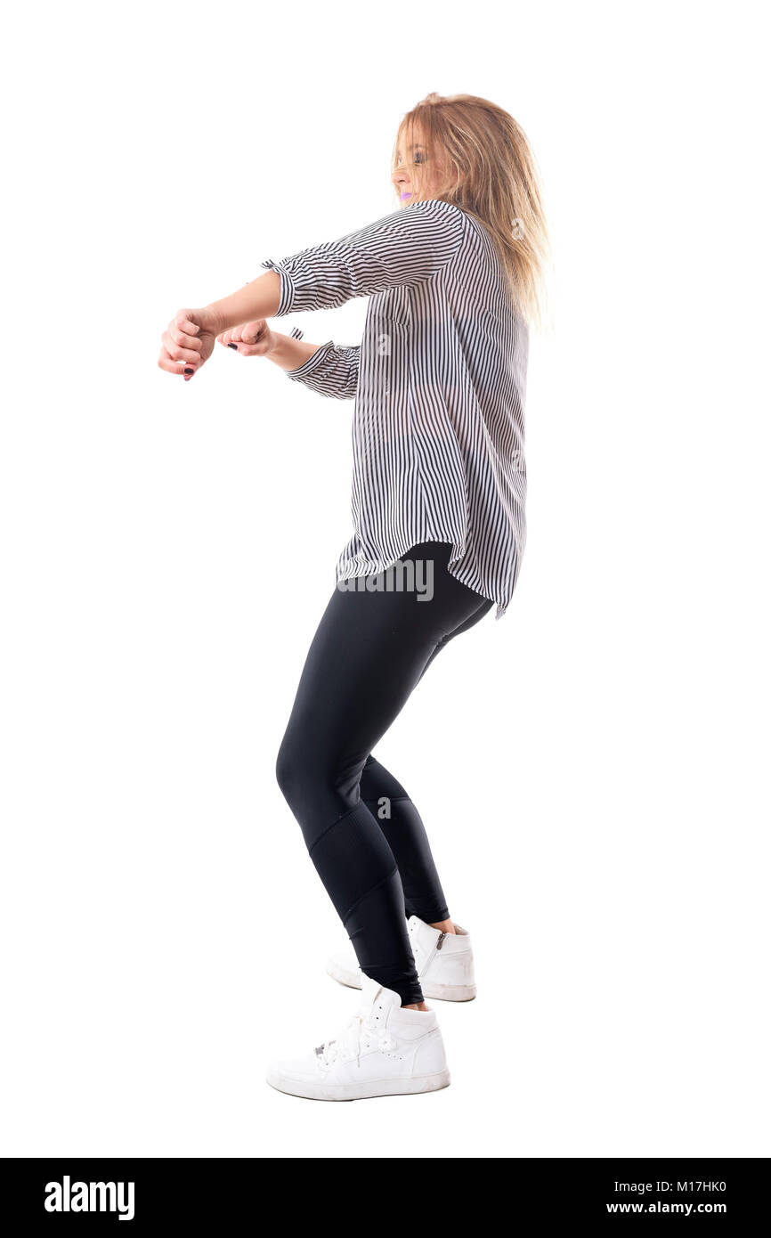 Energetic ecstatic blonde woman dancing. Side view. Full body length ...