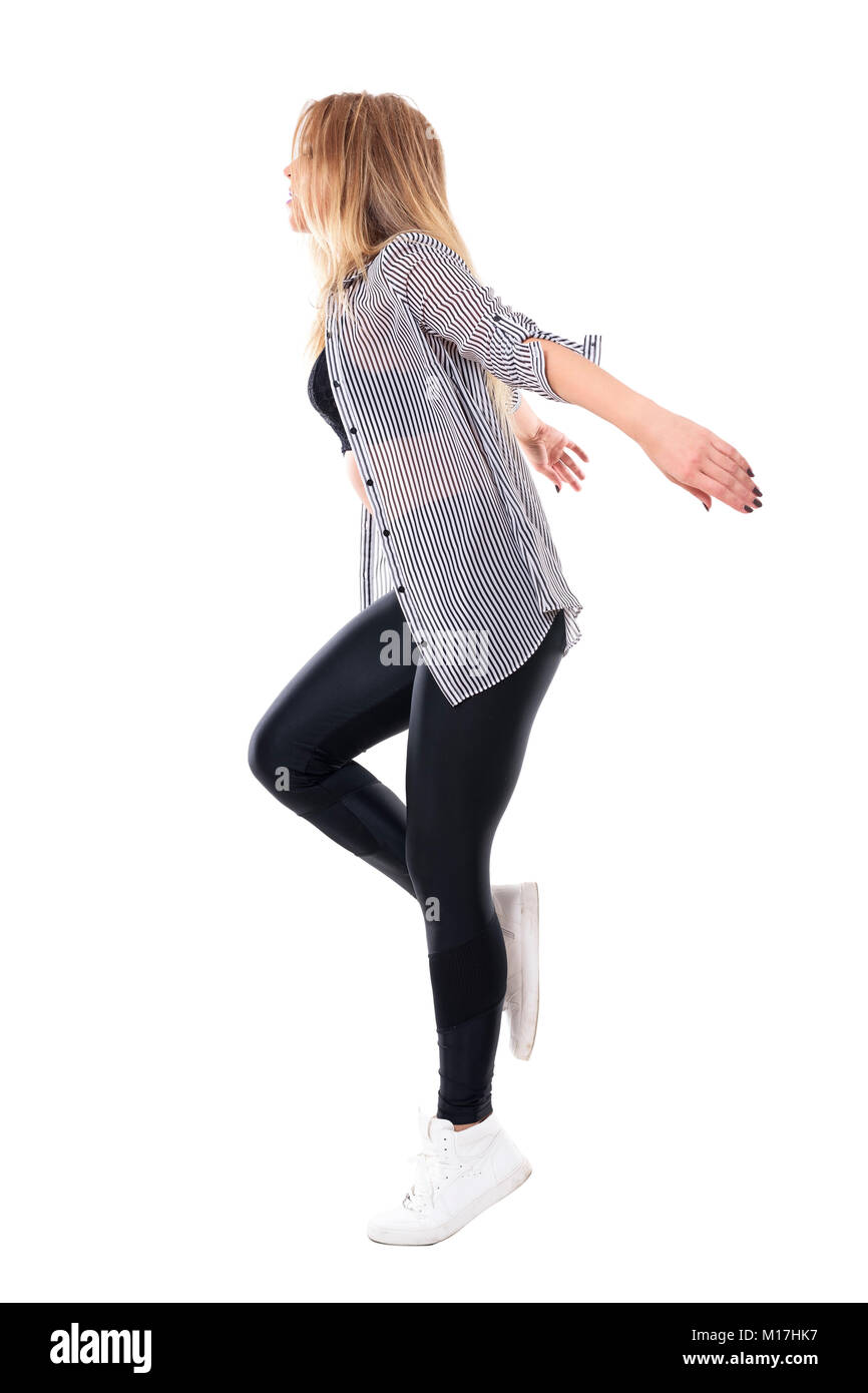 Side view of graceful woman jazz dancer dancing and jumping on one leg ...