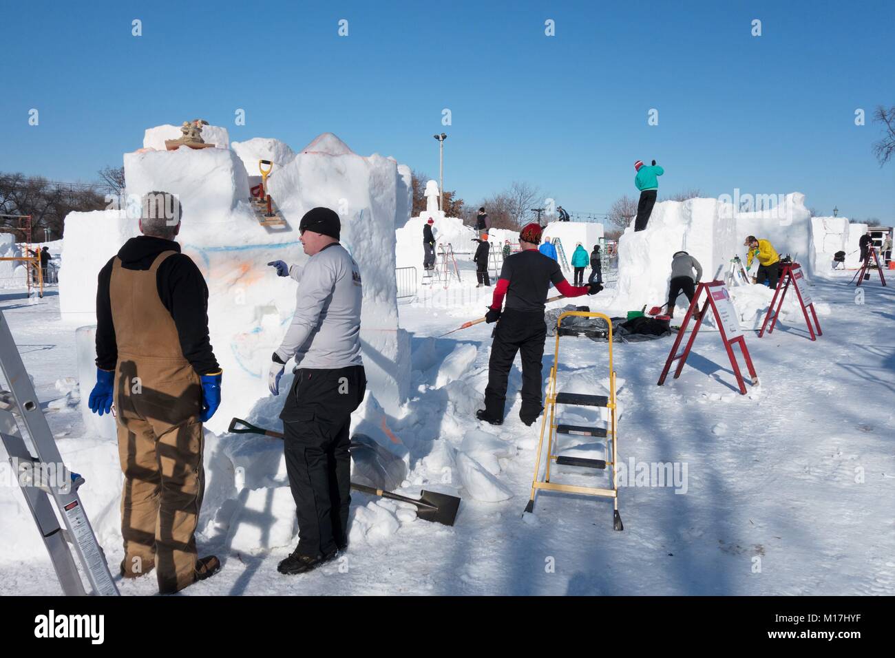 Artists work on huge blocks of snow in the snow sculpting contest, a ...