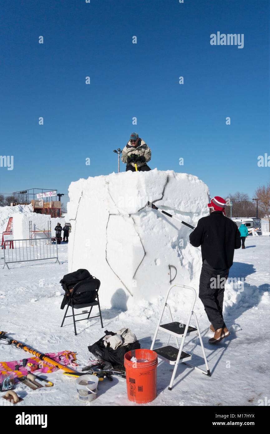 Artists work on huge blocks of snow in the snow sculpting contest, a ...