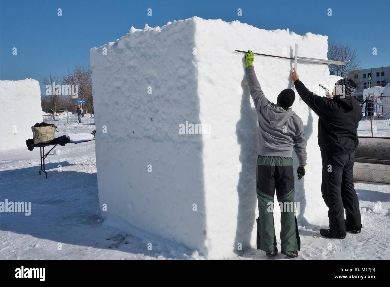Artists work on huge blocks of snow in the snow sculpting contest, a ...