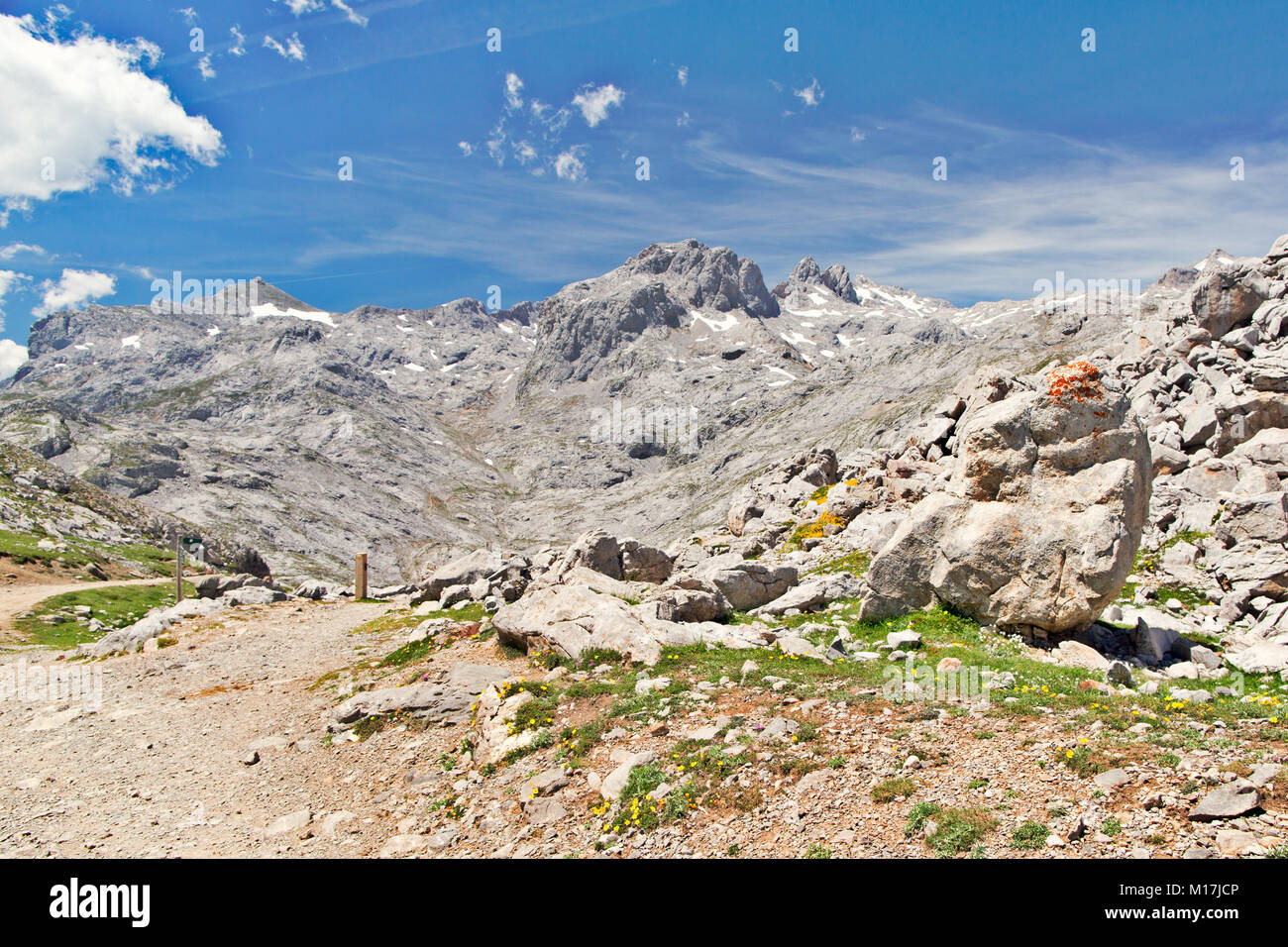 Stony track in mountains of Picos de Europa and tourists, the vicinity of Fuente De. Sunny day ...