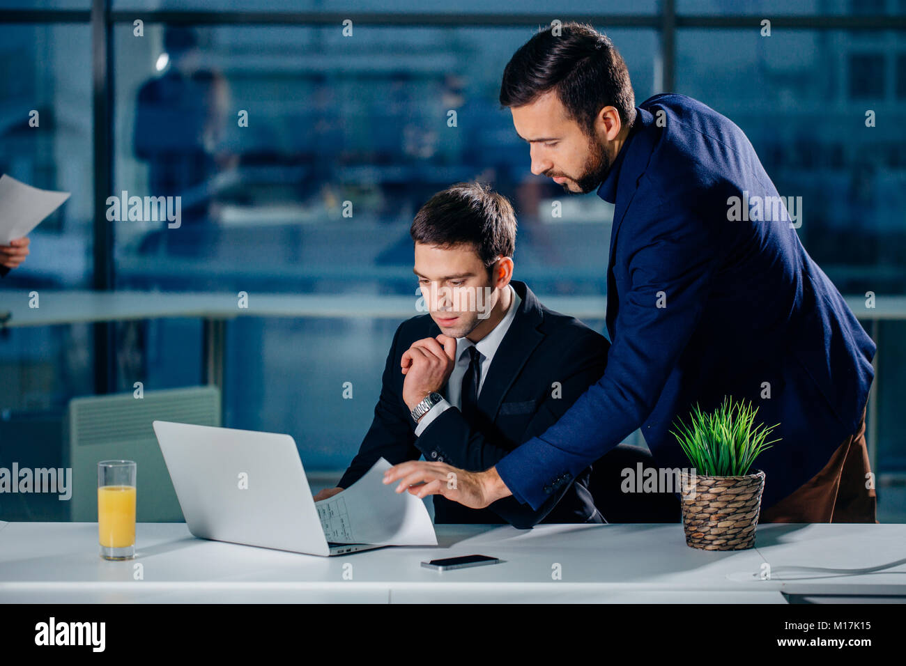 Worried man receiving notification from colleague in her workplace at ...