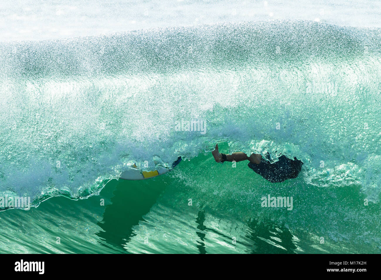 Surfer surfing ocean for a tube ride wipe-out crashing off surfboard ...