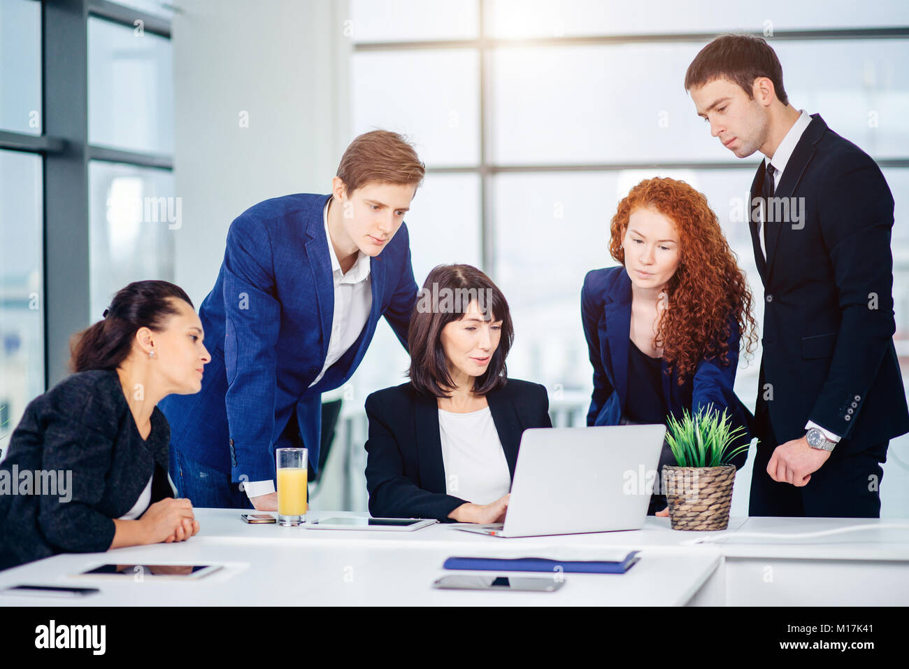 male and female business people around laptop computer in office Stock ...
