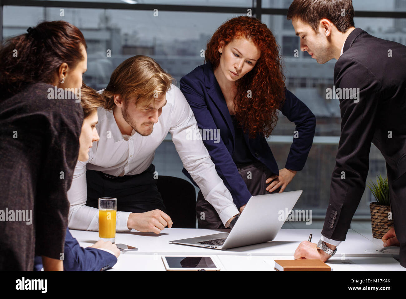 male and female business people around laptop computer in office Stock ...