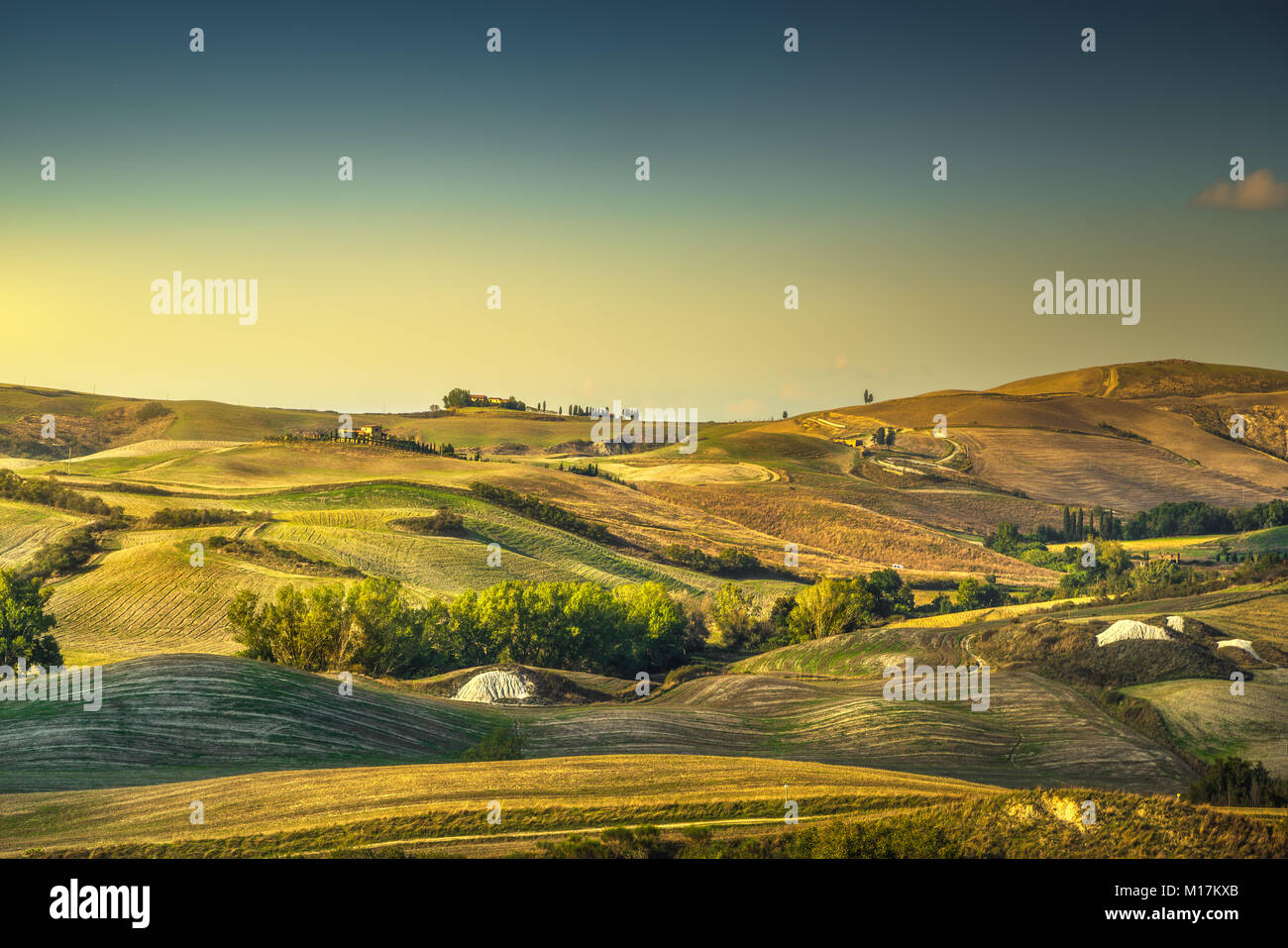 Volterra panorama, rolling hills, trees, and green fields at sunset ...