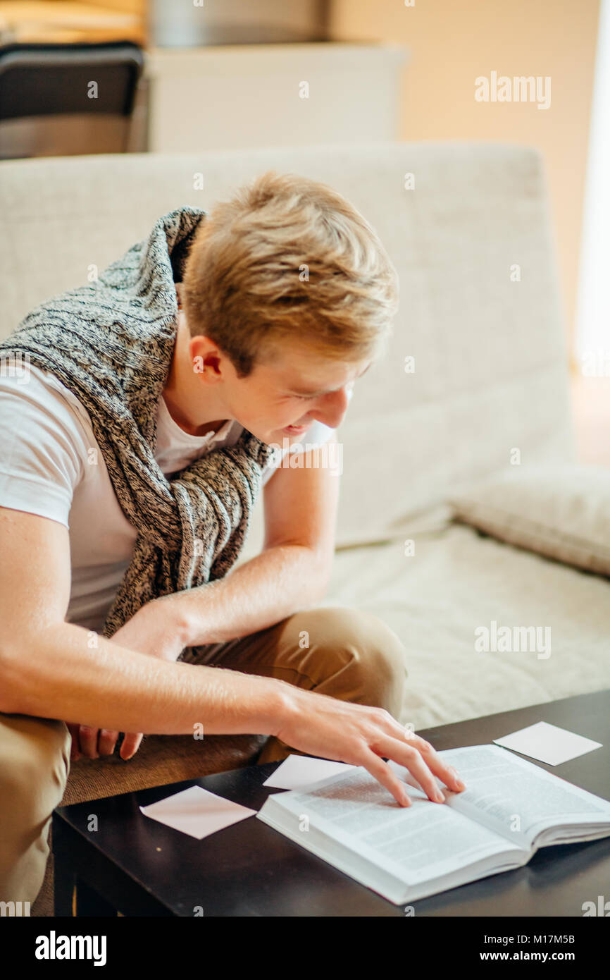 man reading books while sitting sofa Stock Photo - Alamy