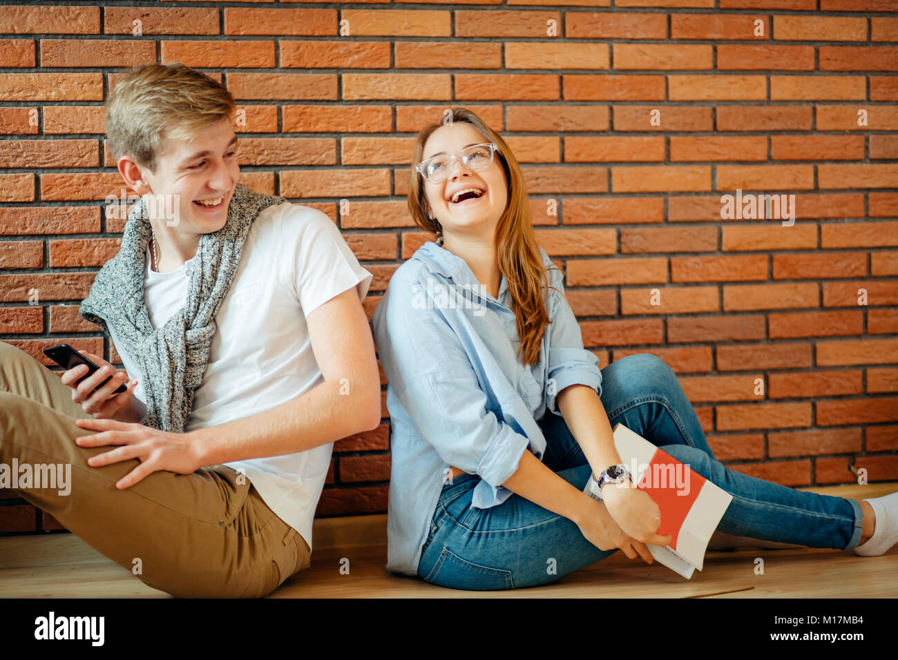 Couple students sitting outside classroom and studying together Stock ...