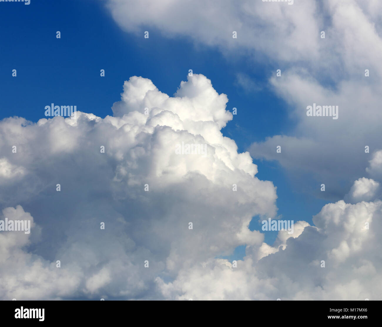 Fluffy white clouds in a blue sky Stock Photo - Alamy