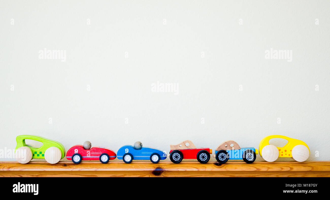 lower third border row of colorful wooden toy cars running along a wood ...