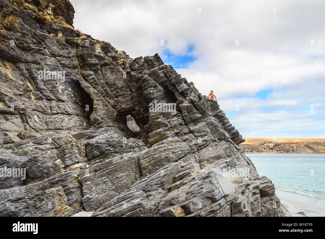 Man sitting on the edge of the cliff at Rapid Bay, South Australia ...