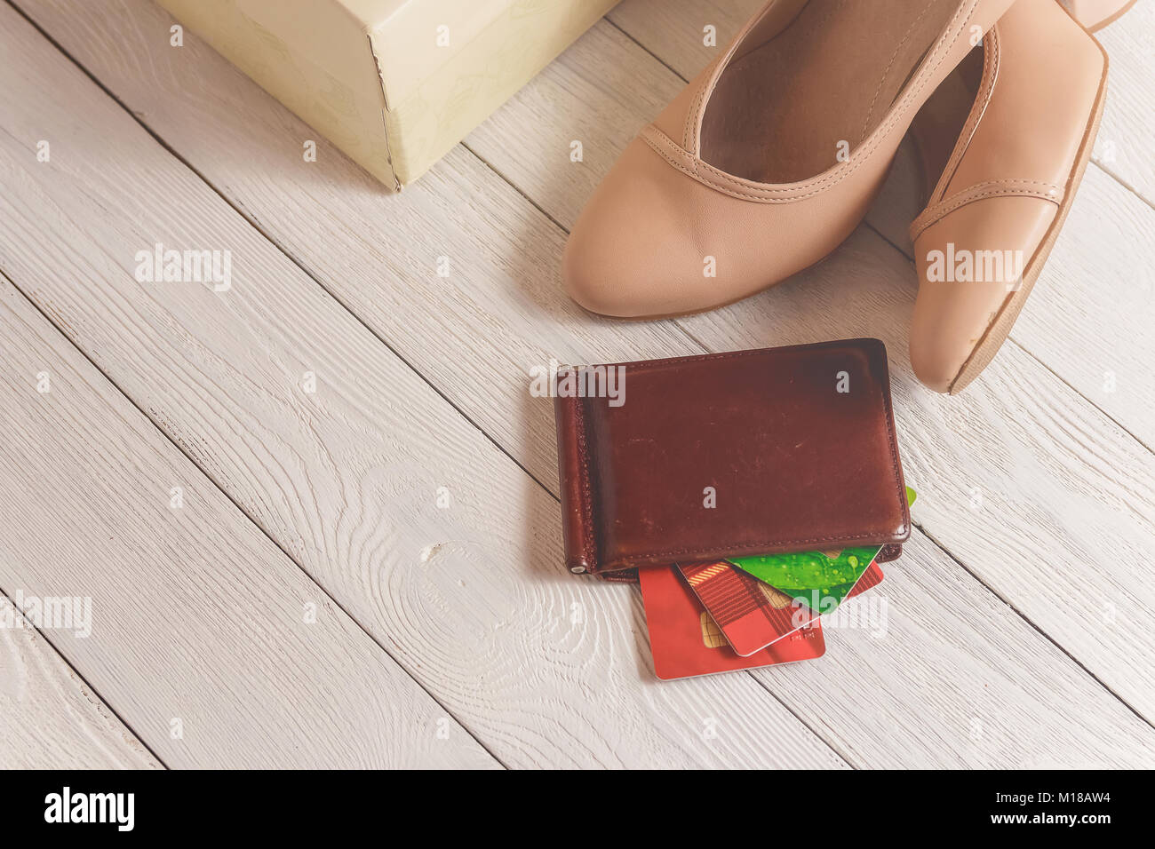 Box, wallet, credit cards and womans shoes lying on the white wooden ...