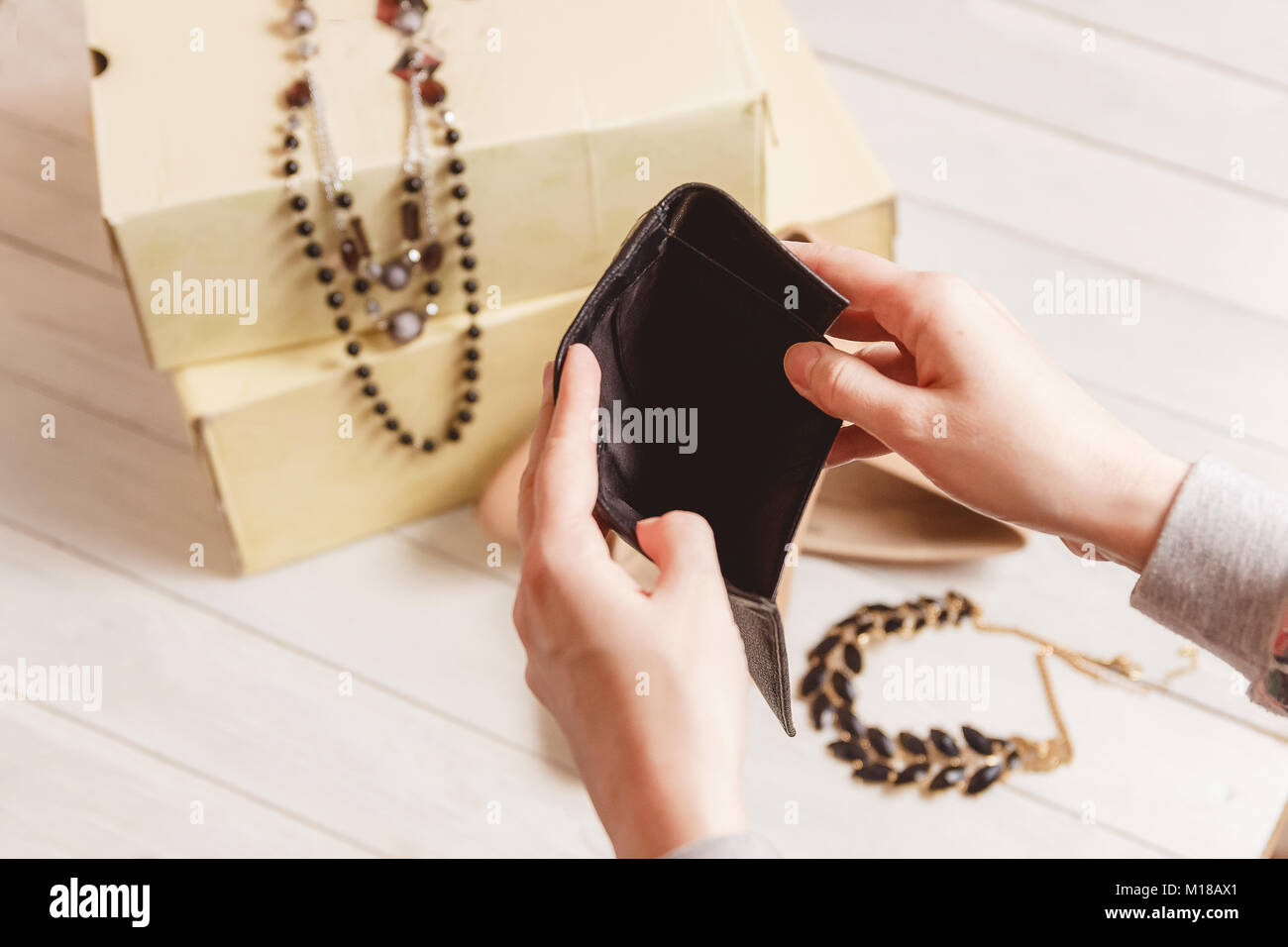 female hands open the empty purse against women clothing and ...