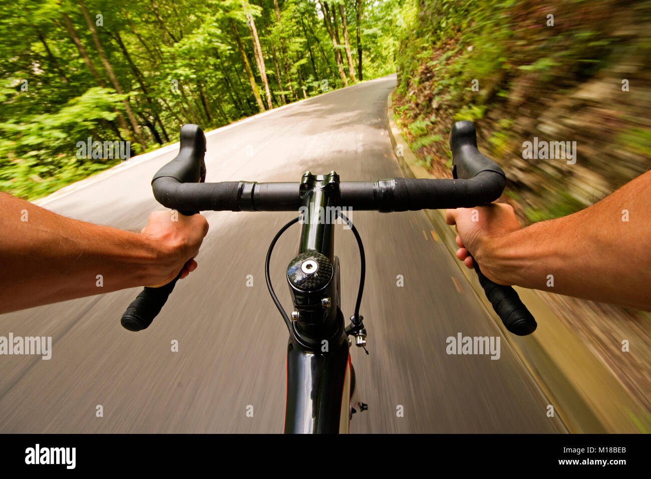 Cyclist riding a bike on the road in nature Stock Photo - Alamy
