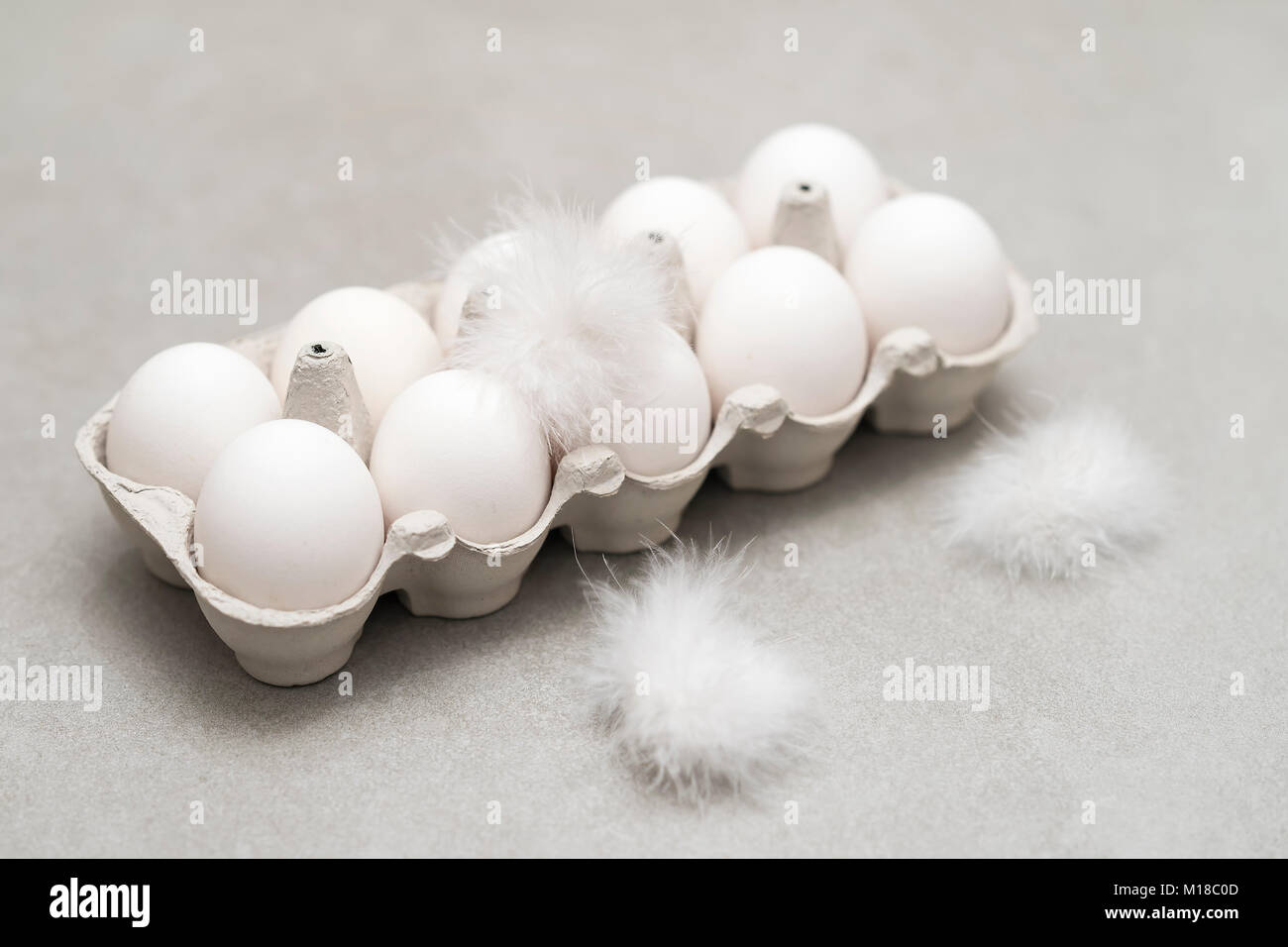 Ten chicken eggs in carton package with feathers, diagonal. Concept for ...