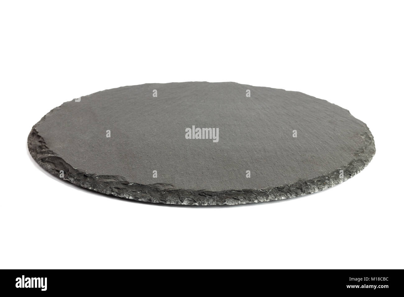 Round rustic black slate stone plate, isolated on white background ...