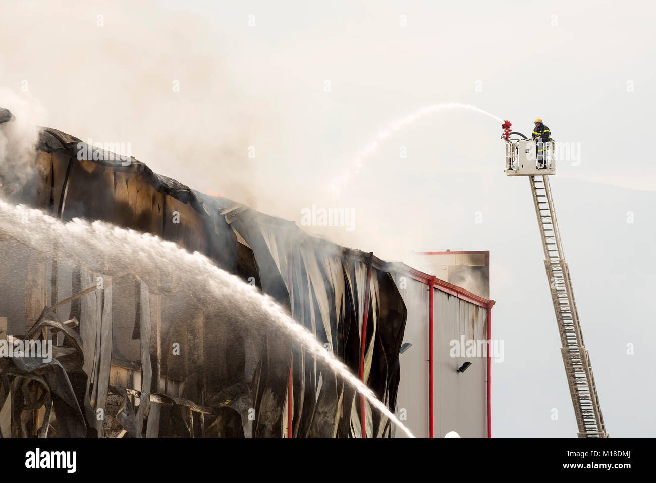 Fire disaster in a warehouse. Fire fighting in an industrial area Stock ...