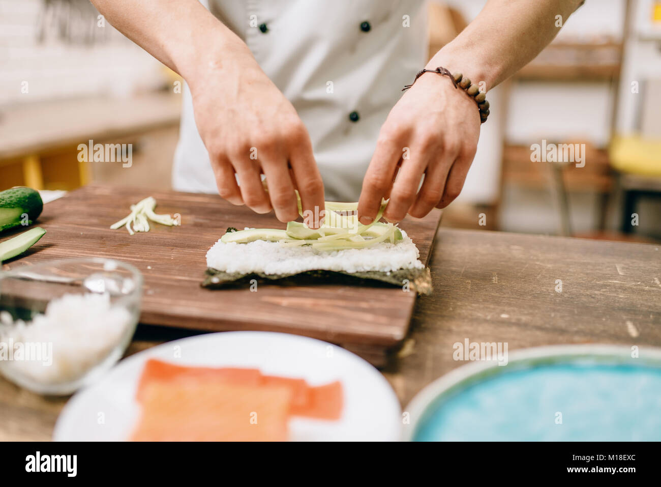 Male cook hands, making sushi rolls, seafood. Traditional japanese ...