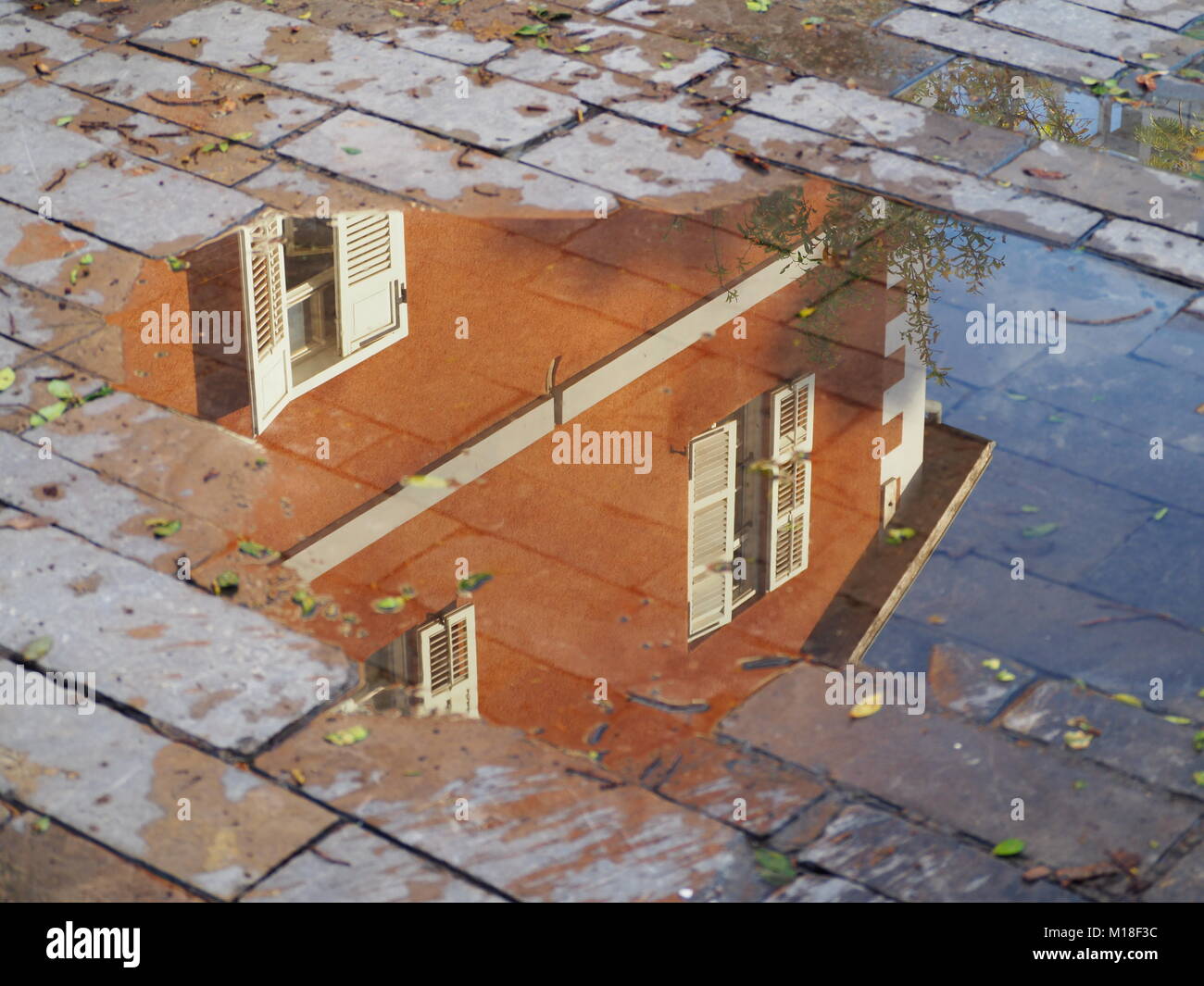 Beautiful photo of old house reflected through rain puddle on stone ...