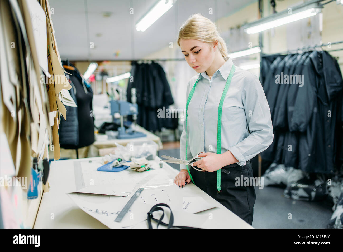 Clothes designer measures a pattern, manufacture on sewing factory ...