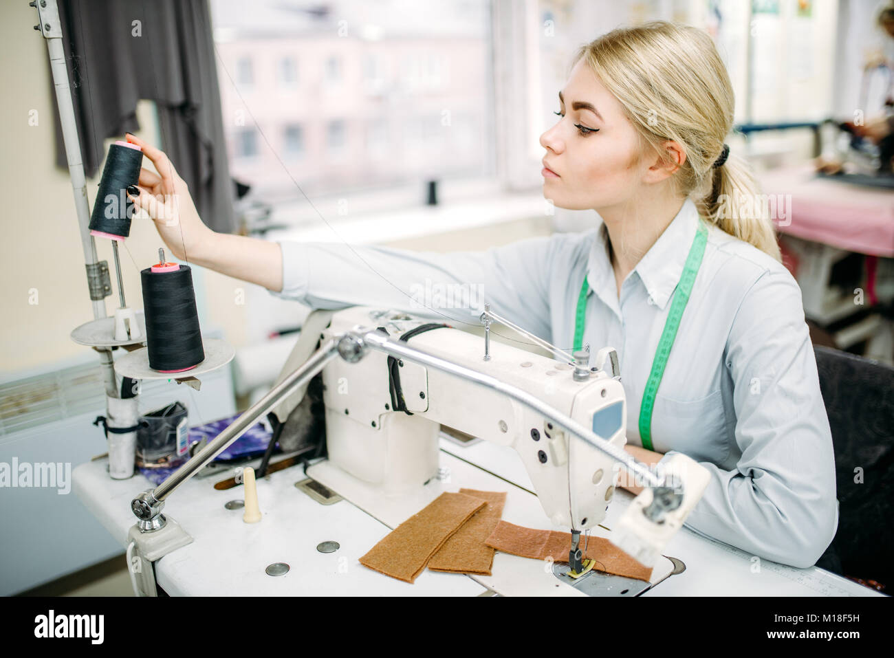 Female dressmaker sews on serger machine. Tailoring or dressmaking on ...