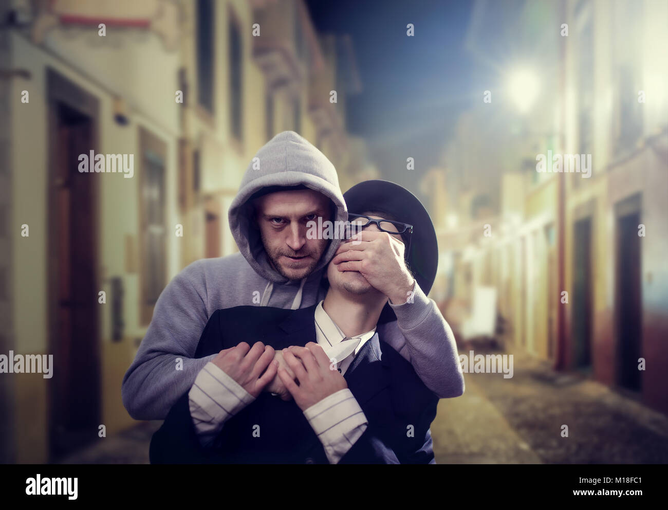 Aggressive thief with knife attack his victim on the night street ...