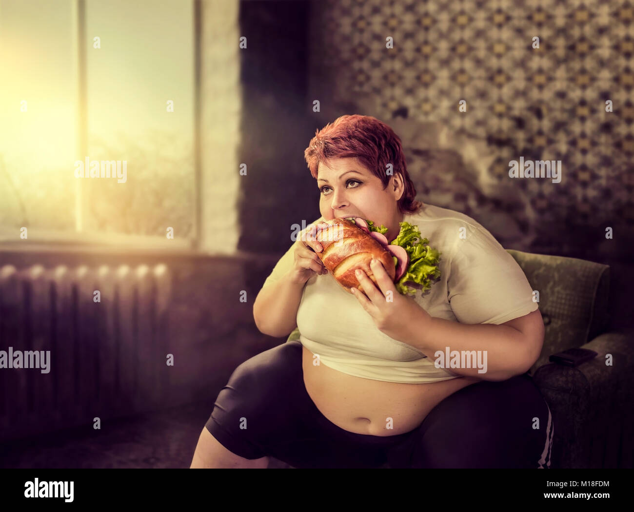 Overweight woman sits in a chair and eats sandwich, bulimic. Unhealthy ...