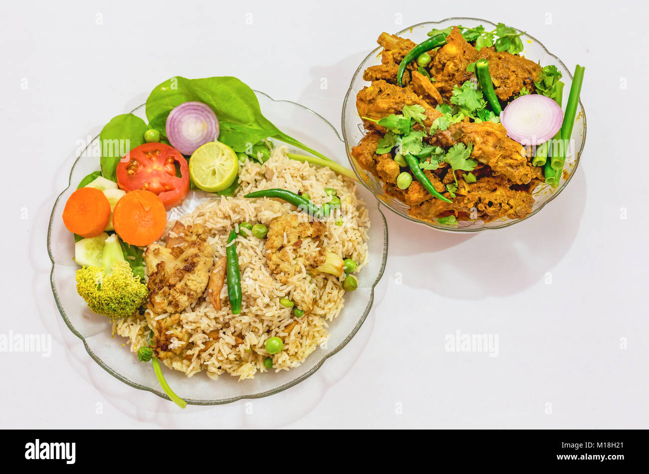 Indian meal of veg fried rice and spicy chicken kosha isolated on white ...
