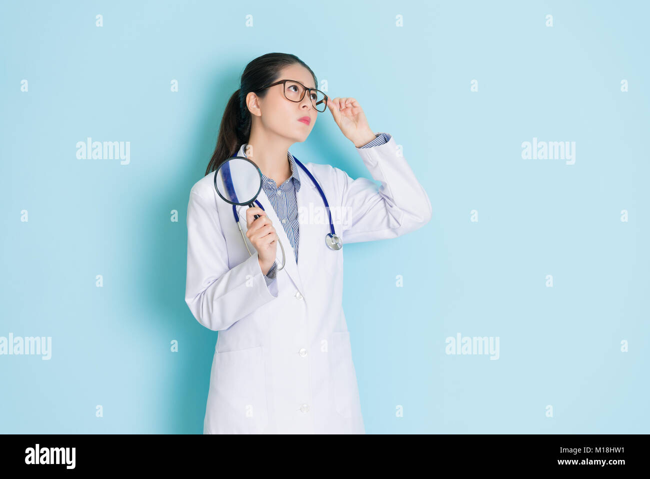 pretty elegant woman doctor holding magnifier tool looking at empty ...