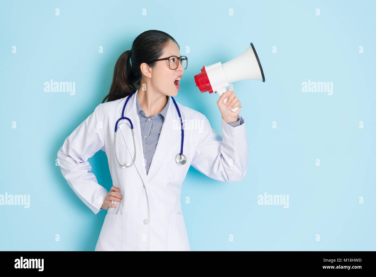 angry seriously doctor woman holding loudspeaker shouting isolated on ...