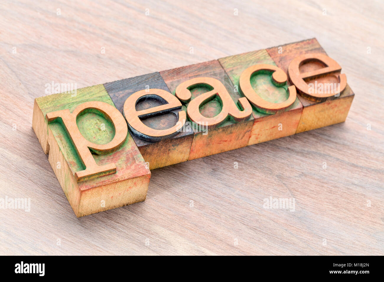 peace word abstract in letterpress wood type blocks stained by color ...