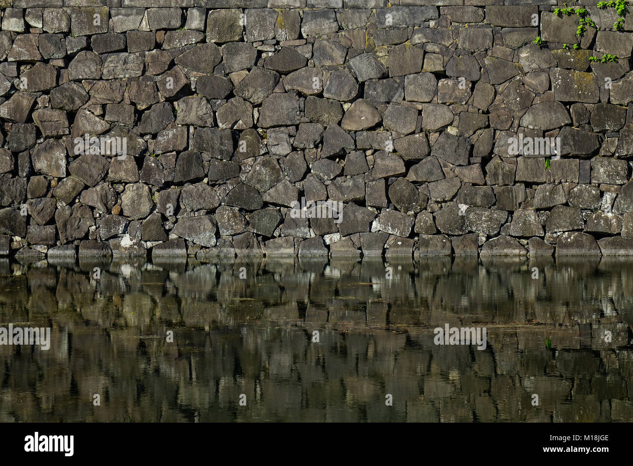 Stone wall of ancient castle with moat in Tokyo, Japan Stock Photo - Alamy