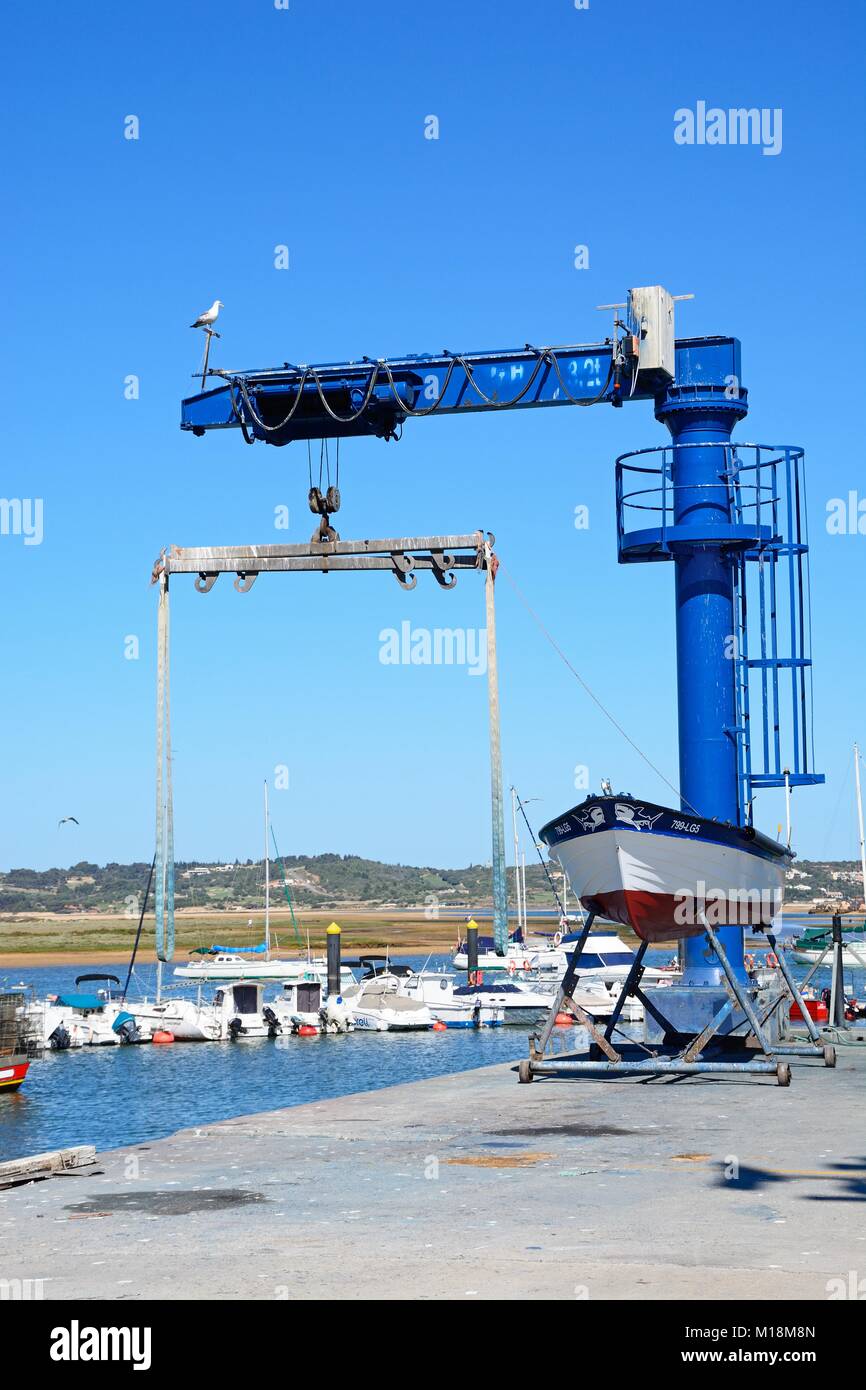 Fishing boat in dry dock with a crane to the rear, Alvor, Algarve ...
