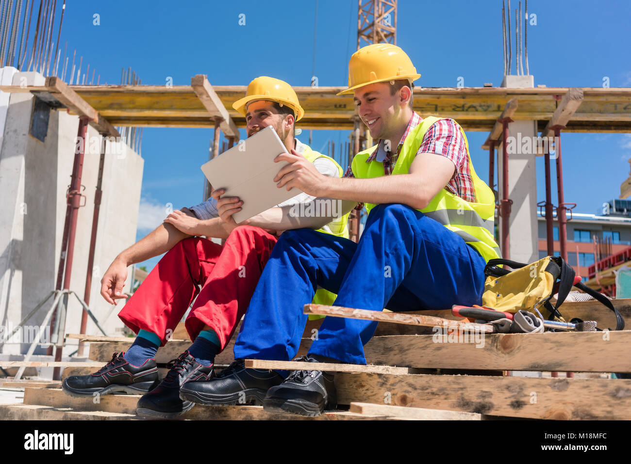 Two workers reading online information or watching a video on a Stock ...
