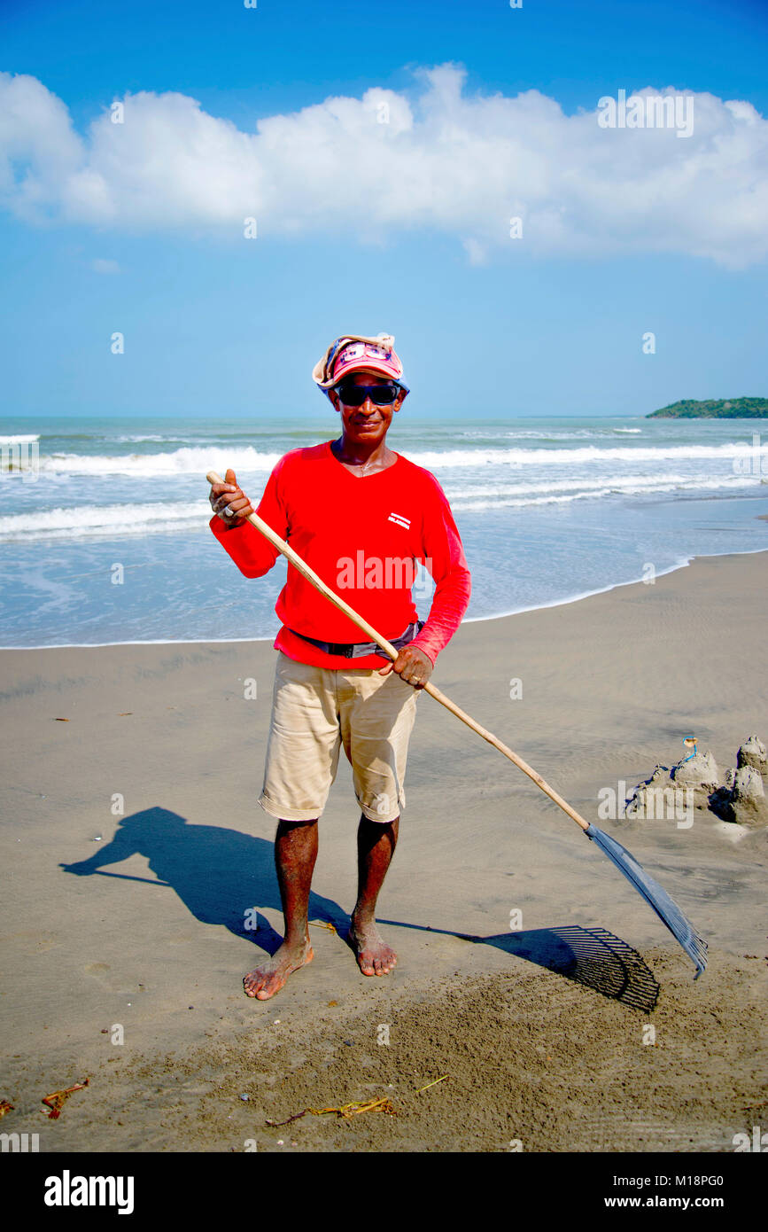 beachman with rake smooths sandy beach Stock Photo - Alamy