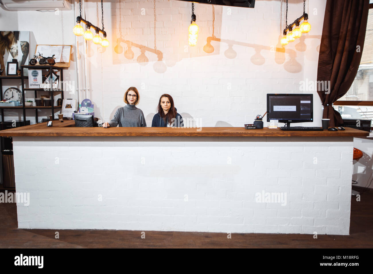 Receptionist standing at reception counter in office Stock Photo - Alamy