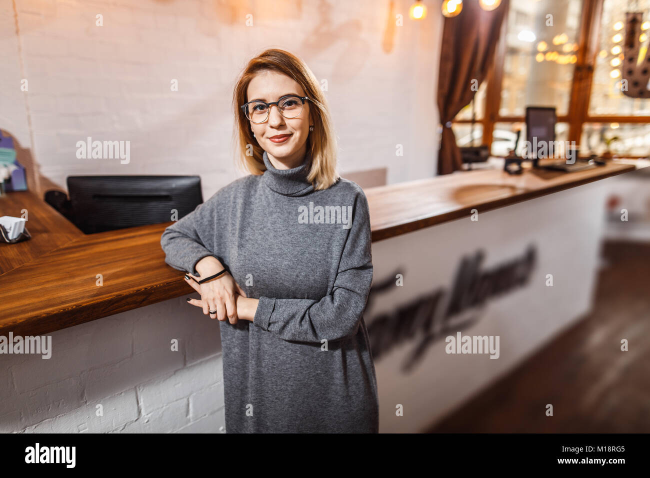Receptionist standing at reception counter in office Stock Photo - Alamy
