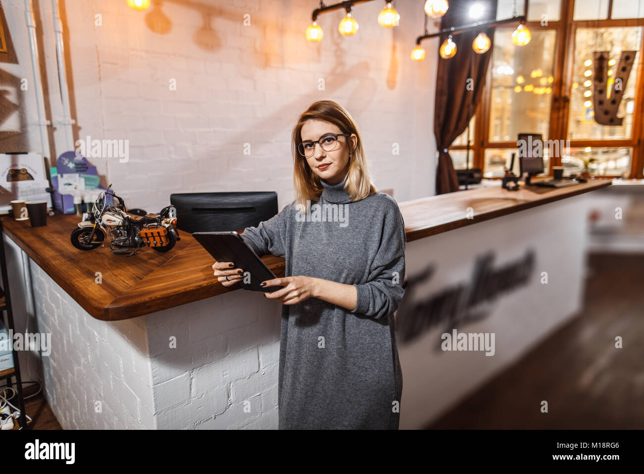 Receptionist standing at reception counter in office Stock Photo - Alamy