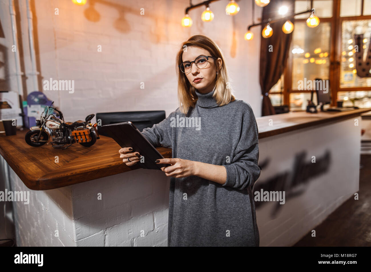 Receptionist standing at reception counter in office Stock Photo - Alamy