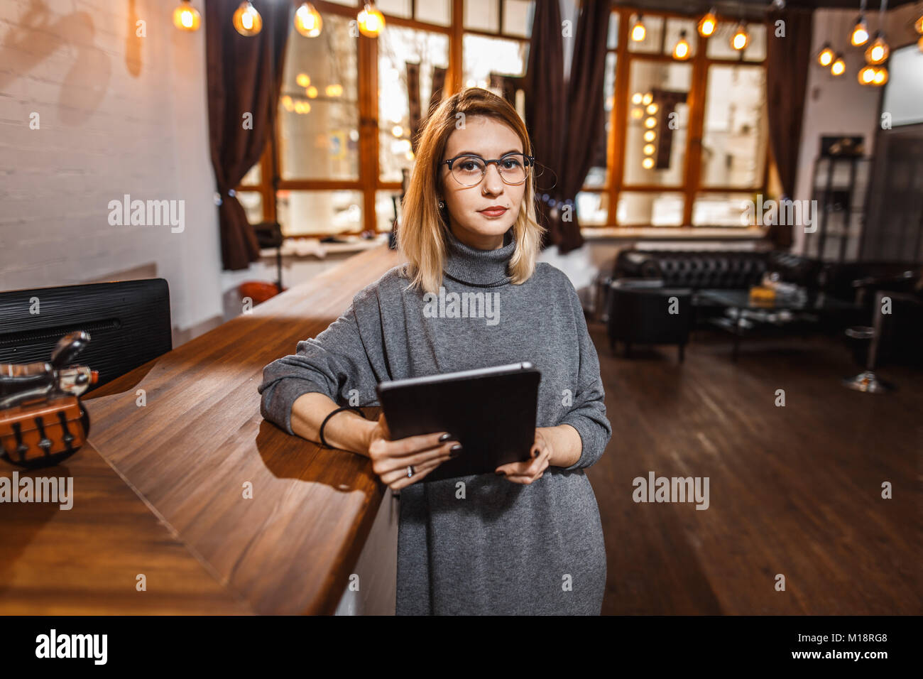 Receptionist standing at reception counter in office Stock Photo - Alamy